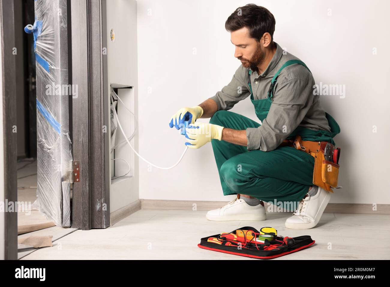Electrician fixing wires with insulating tape indoors Stock Photo - Alamy
