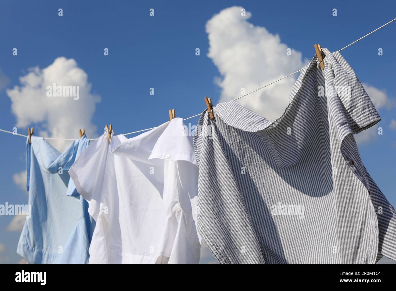 Clean clothes hanging on washing line against sky. Drying laundry Stock ...