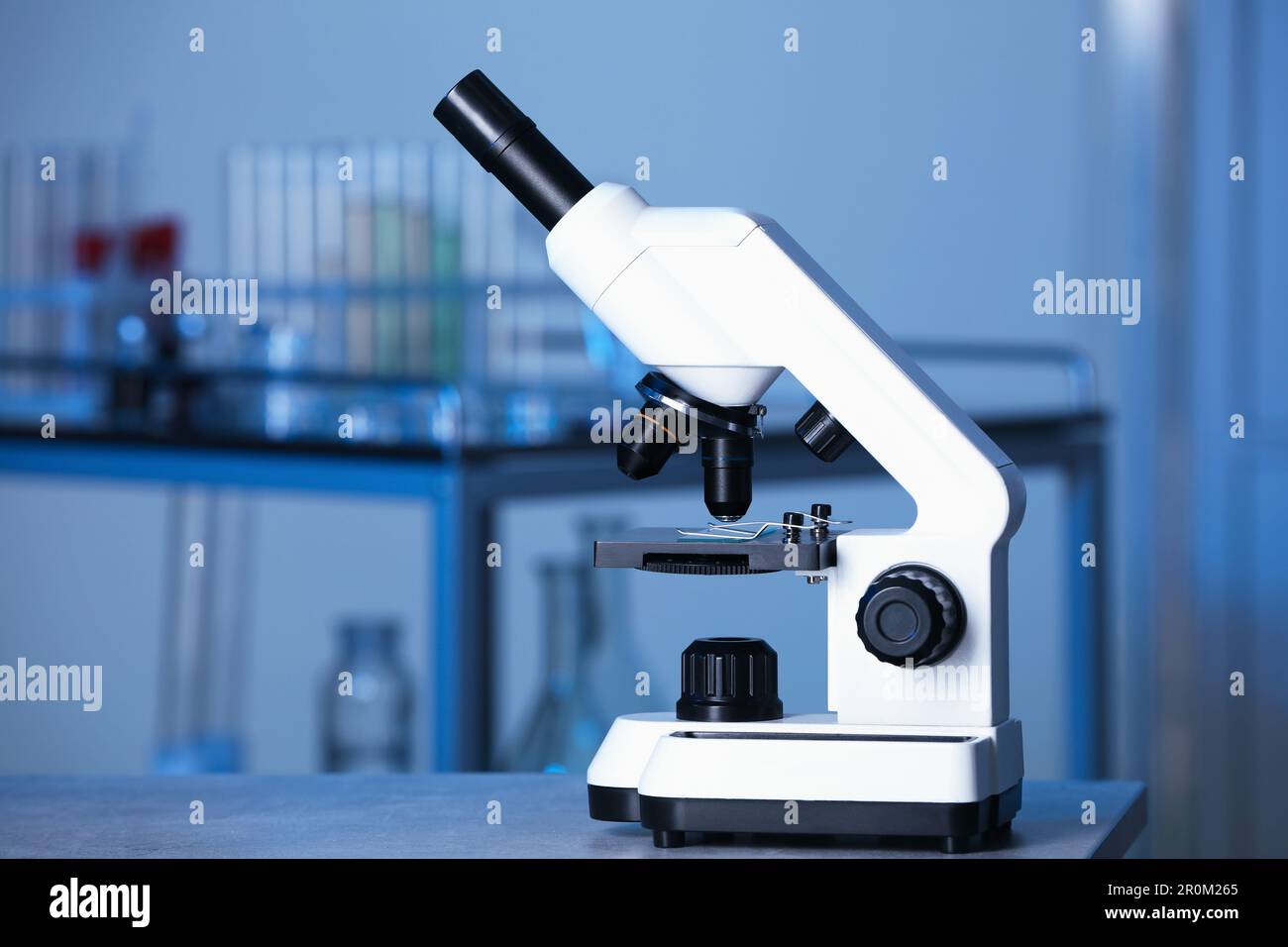 Modern medical microscope on gray table in laboratory, space for text ...