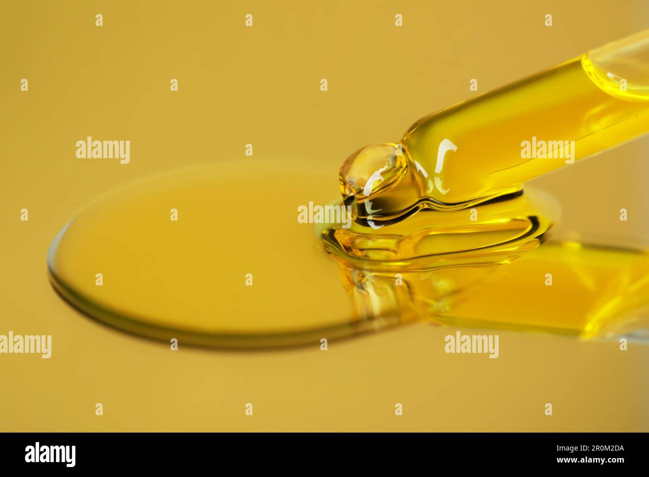 Dripping face serum from pipette on yellow background, closeup Stock ...