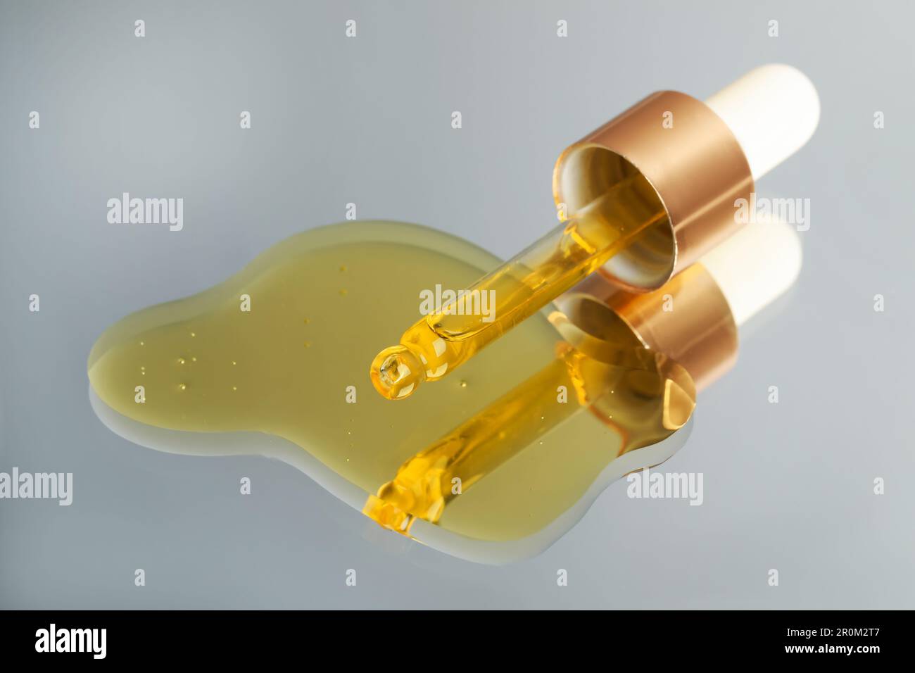 Yellow serum with pipette on mirror, closeup Stock Photo - Alamy