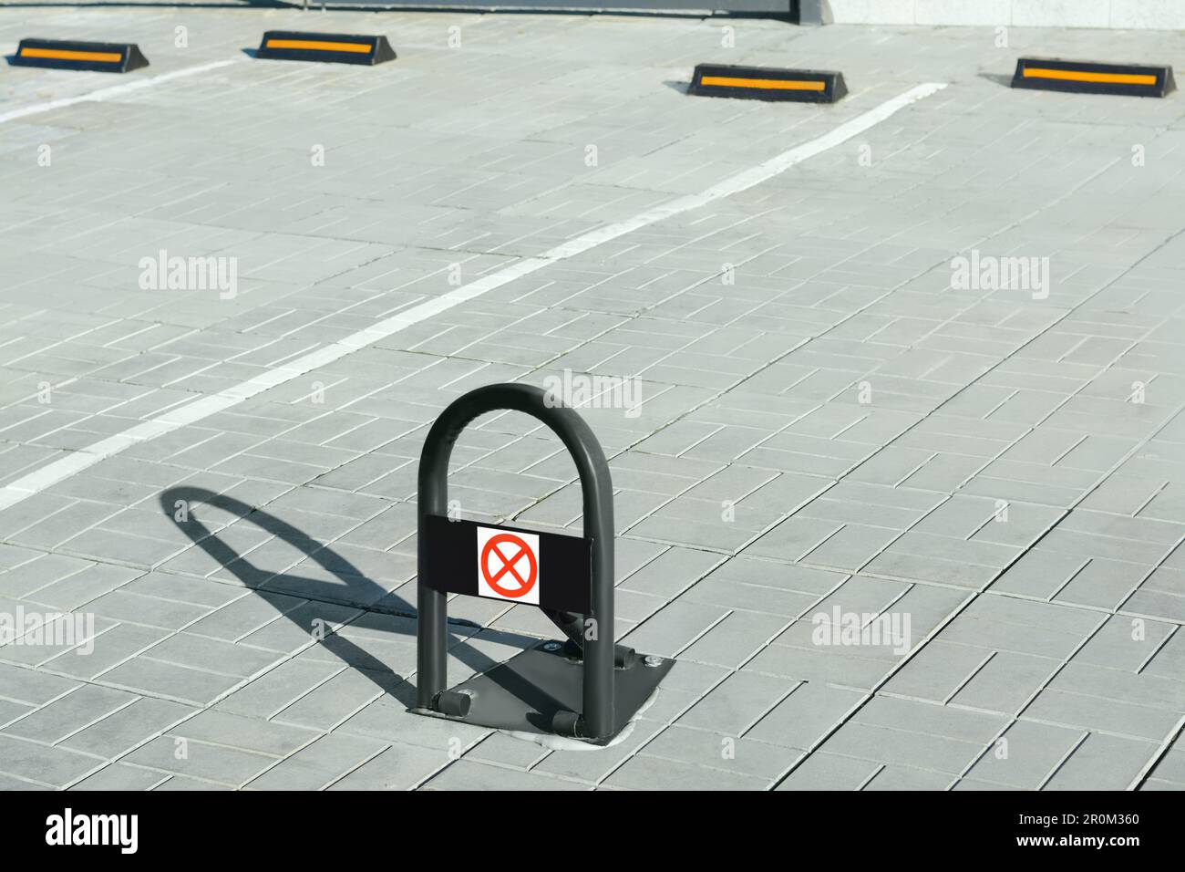 Parking barrier with No Stopping road sign on pavement outdoors, space ...