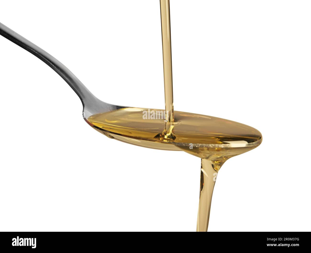 Pouring cooking oil into spoon on white background Stock Photo - Alamy