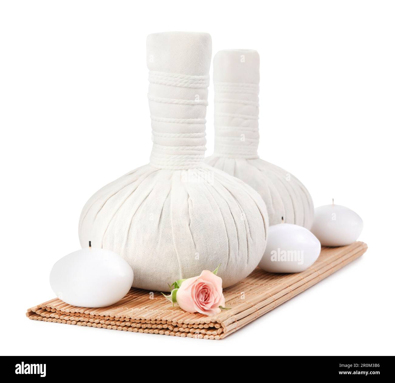 Herbal massage bags, rose and candles on white background. Spa supply ...