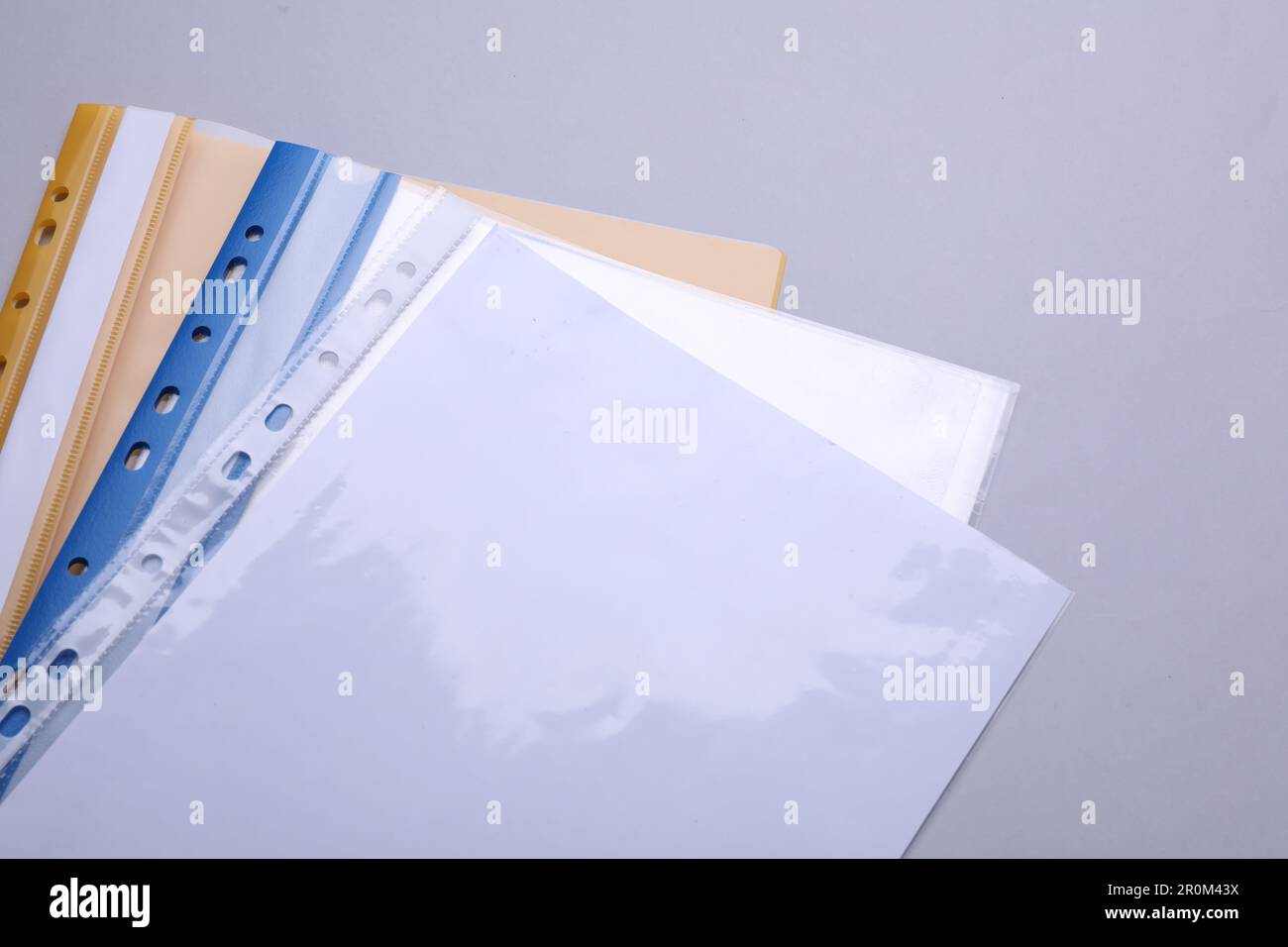 File folders with punched pockets and paper sheets on light grey ...