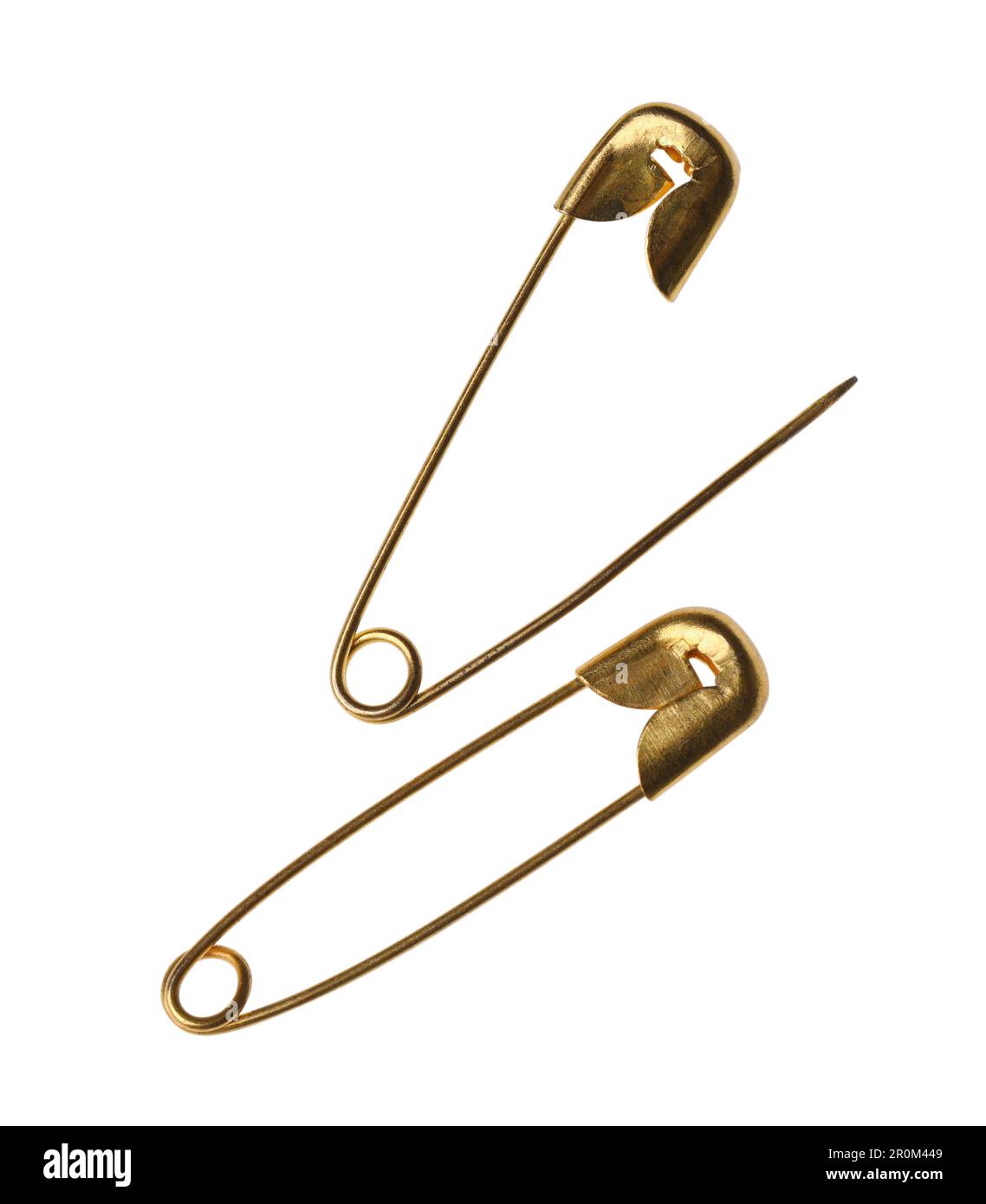 New golden safety pins on white background Stock Photo - Alamy