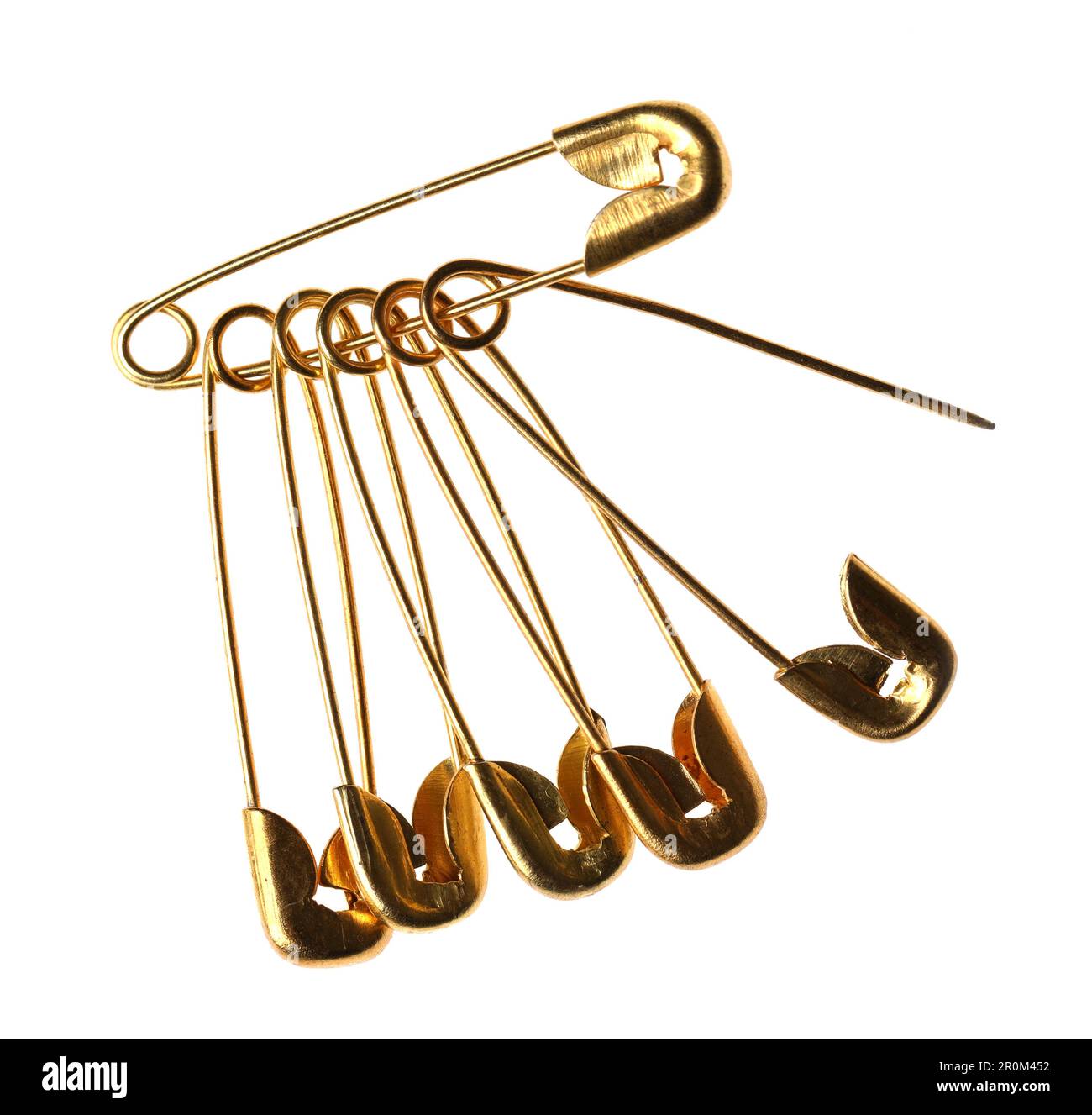 New golden safety pins on white background Stock Photo - Alamy