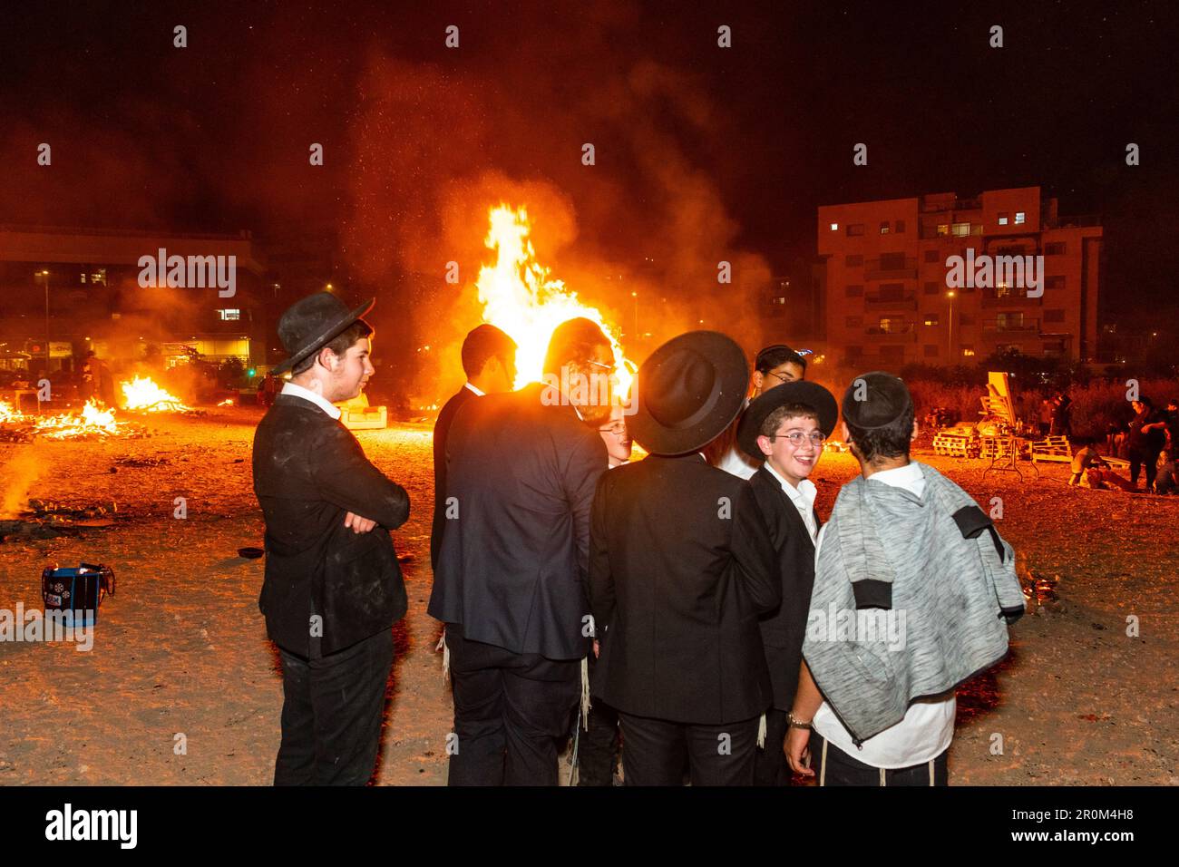 Jewish Ultra Orthodox men ("Haredi") stand near a fire during the ...