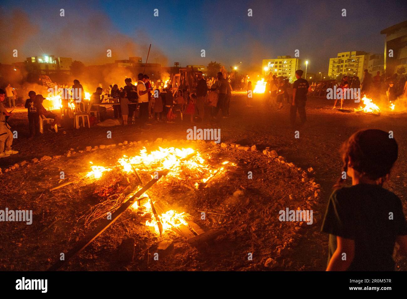 A boy passes near a fire during the Jewish Holiday of Lag Ba'Omer ...