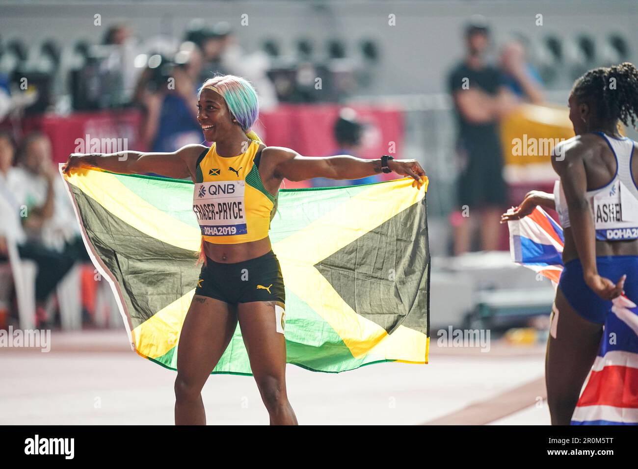 Shelly-Ann Fraser-Pryce with her country's flag after medaling in the ...