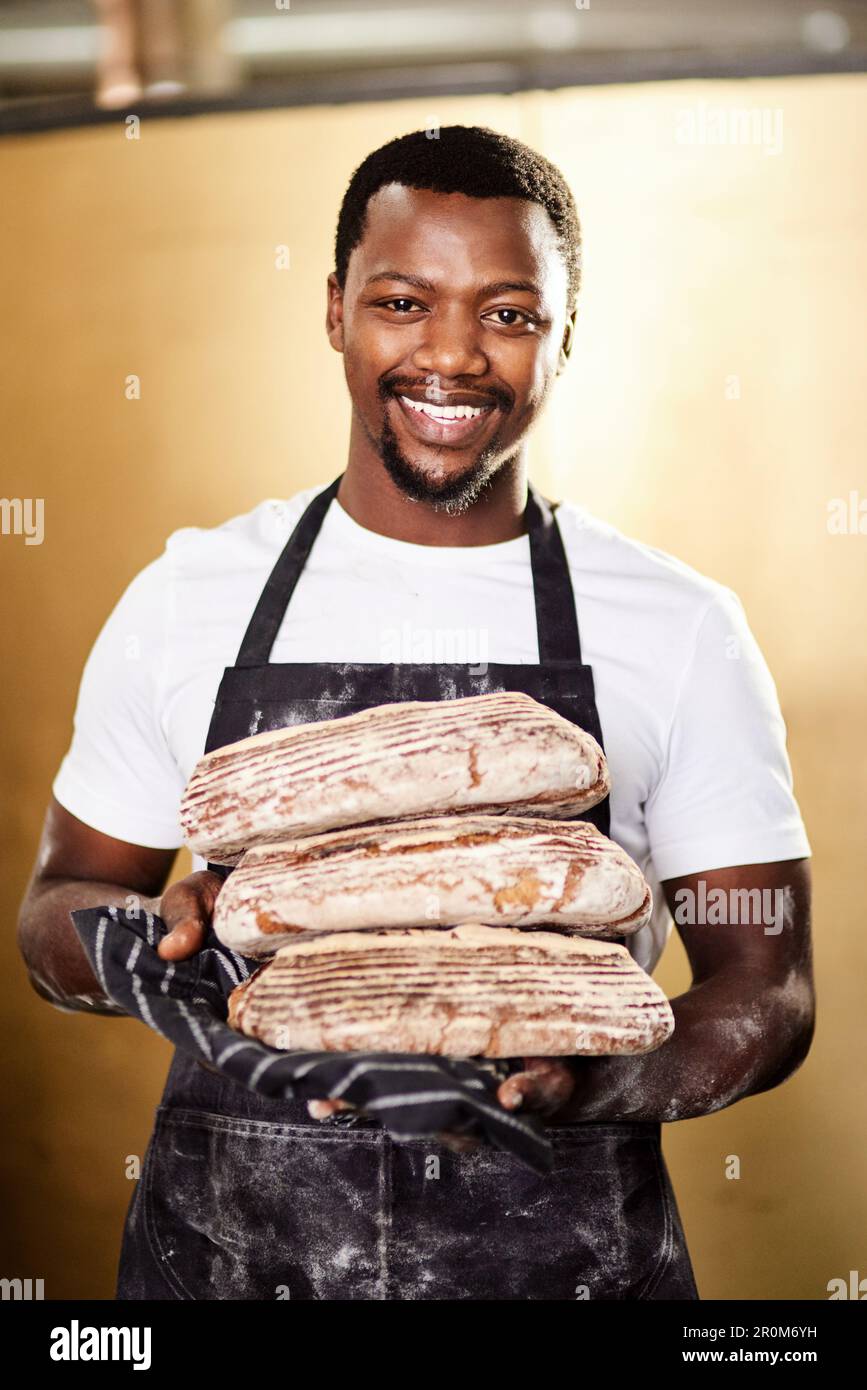 Its famous because its good. a male baker holding up freshly baked ...
