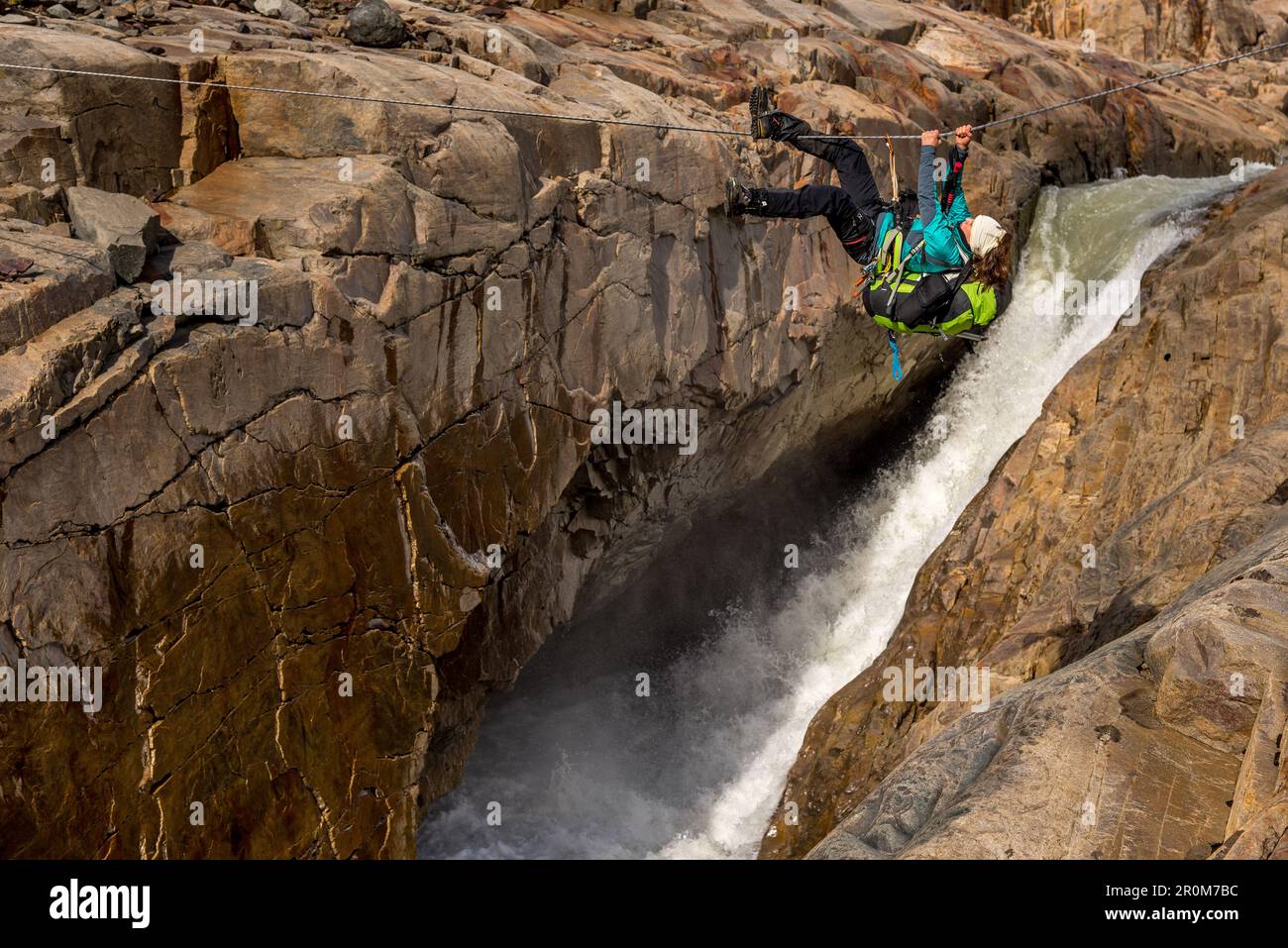 A female hiker crosses the Rio Electrico on a zip line (Tirolesa), Los ...
