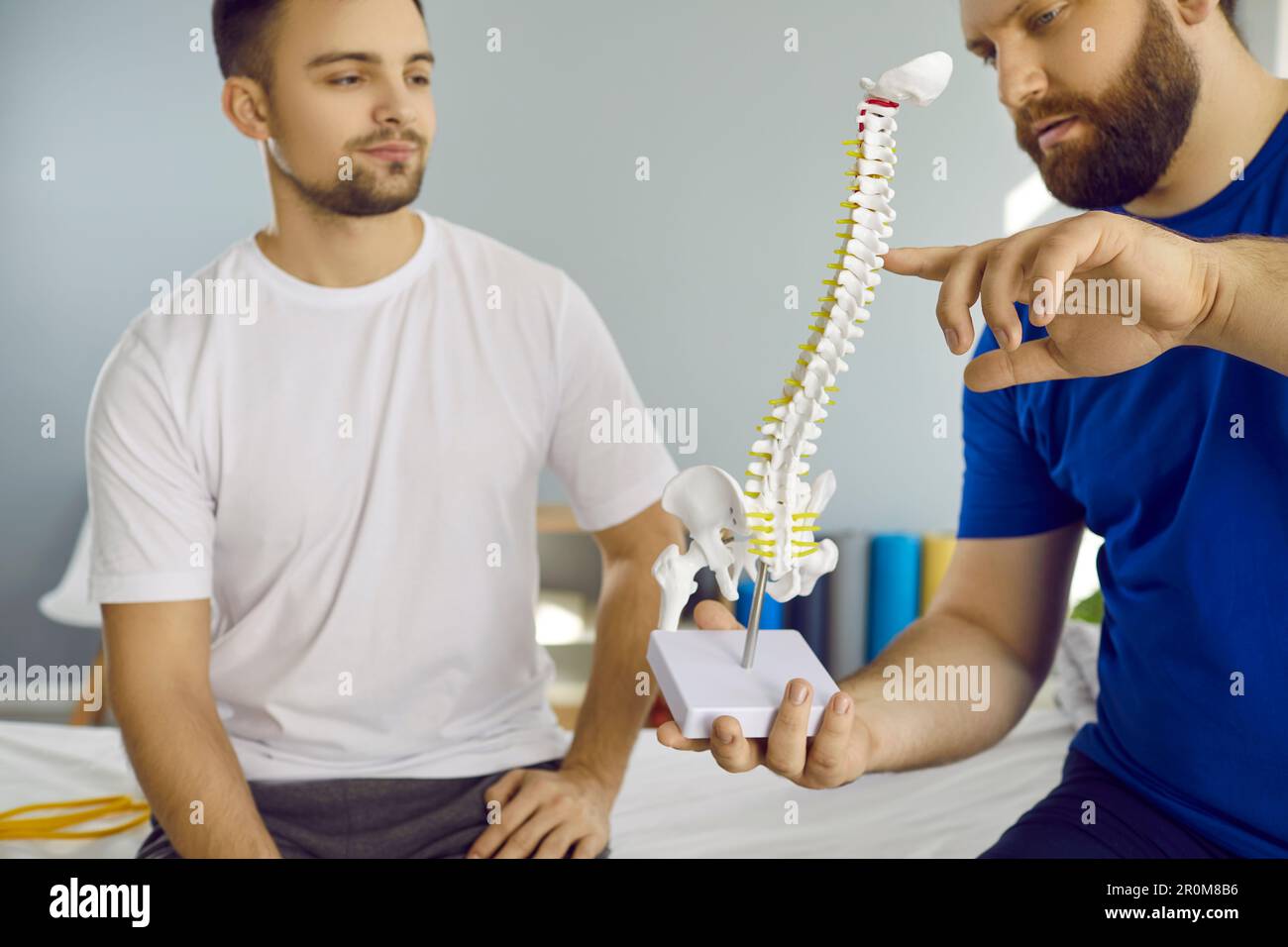 Young man with spine problems on consultation with osteopath showing ...