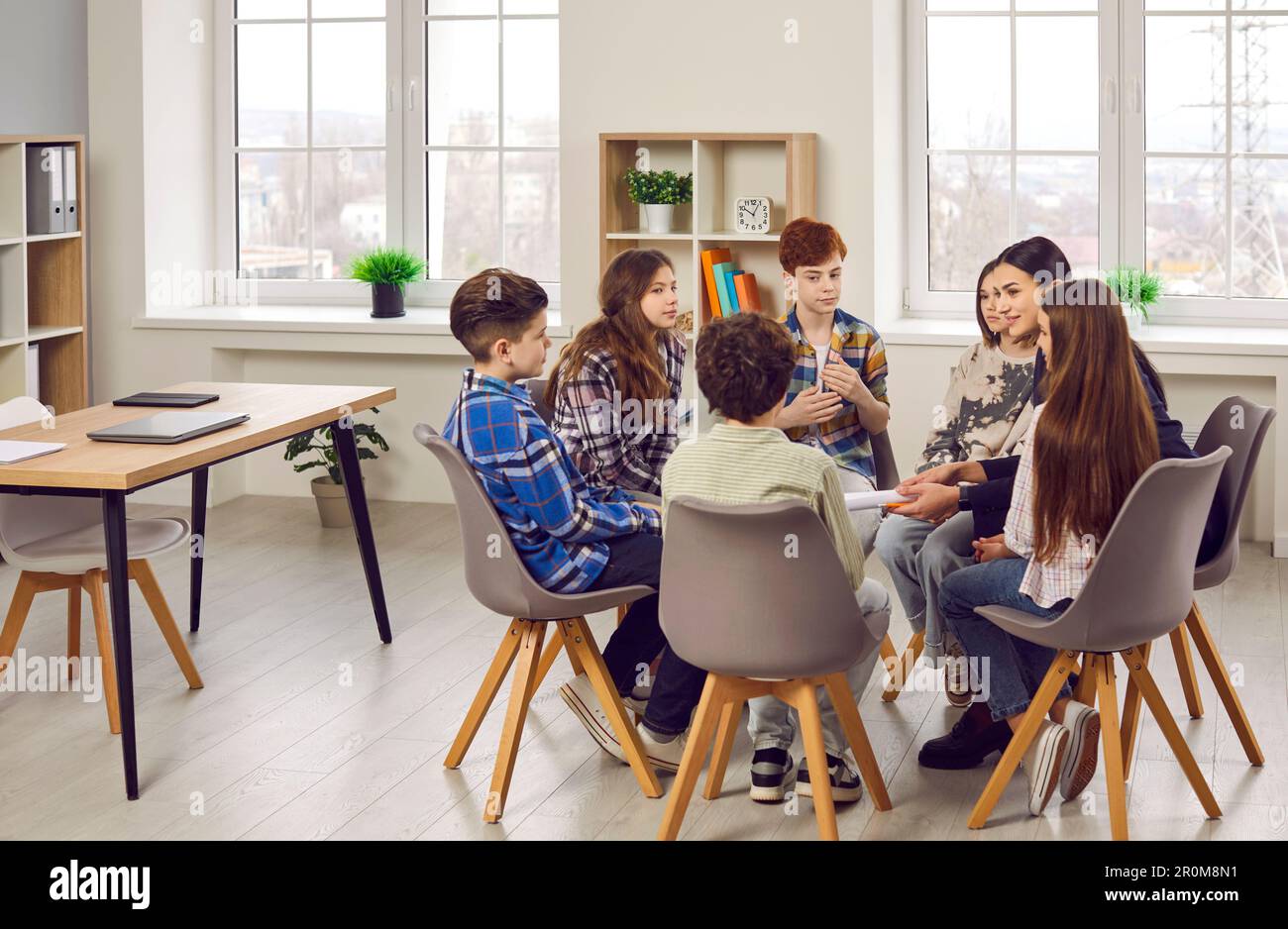 School children together with their teacher discussing something in the ...