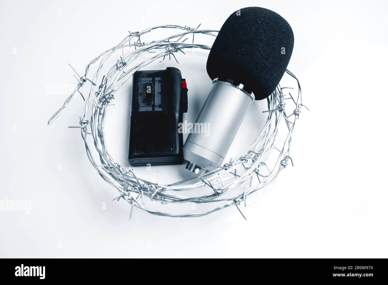 Microphone and recording device with barbed wire on white background ...