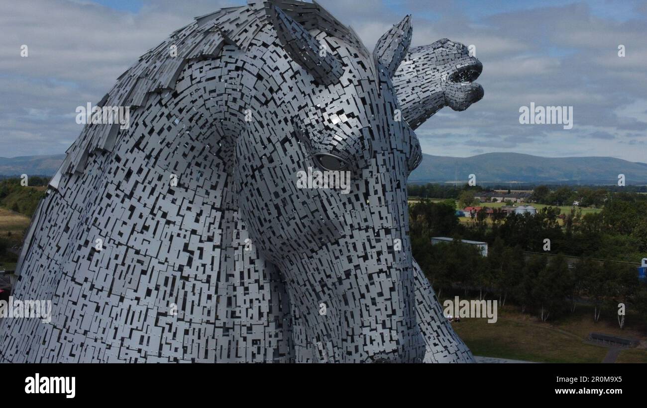 An aerial shot of a sculpture of two horseheads, The Kelpies in the ...