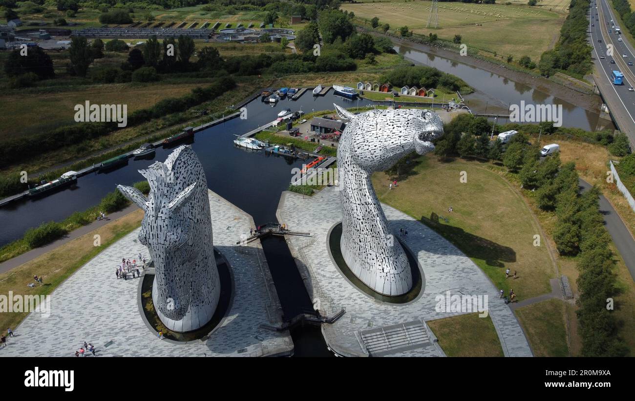An aerial shot of a sculpture of two horseheads, The Kelpies in the ...