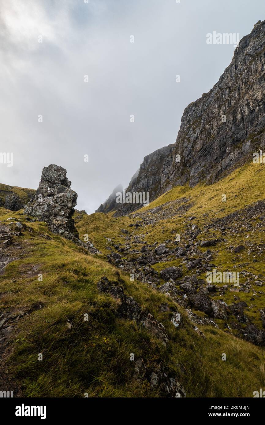 A scenic landscape of rolling hills, with tall, jutting rocks ...