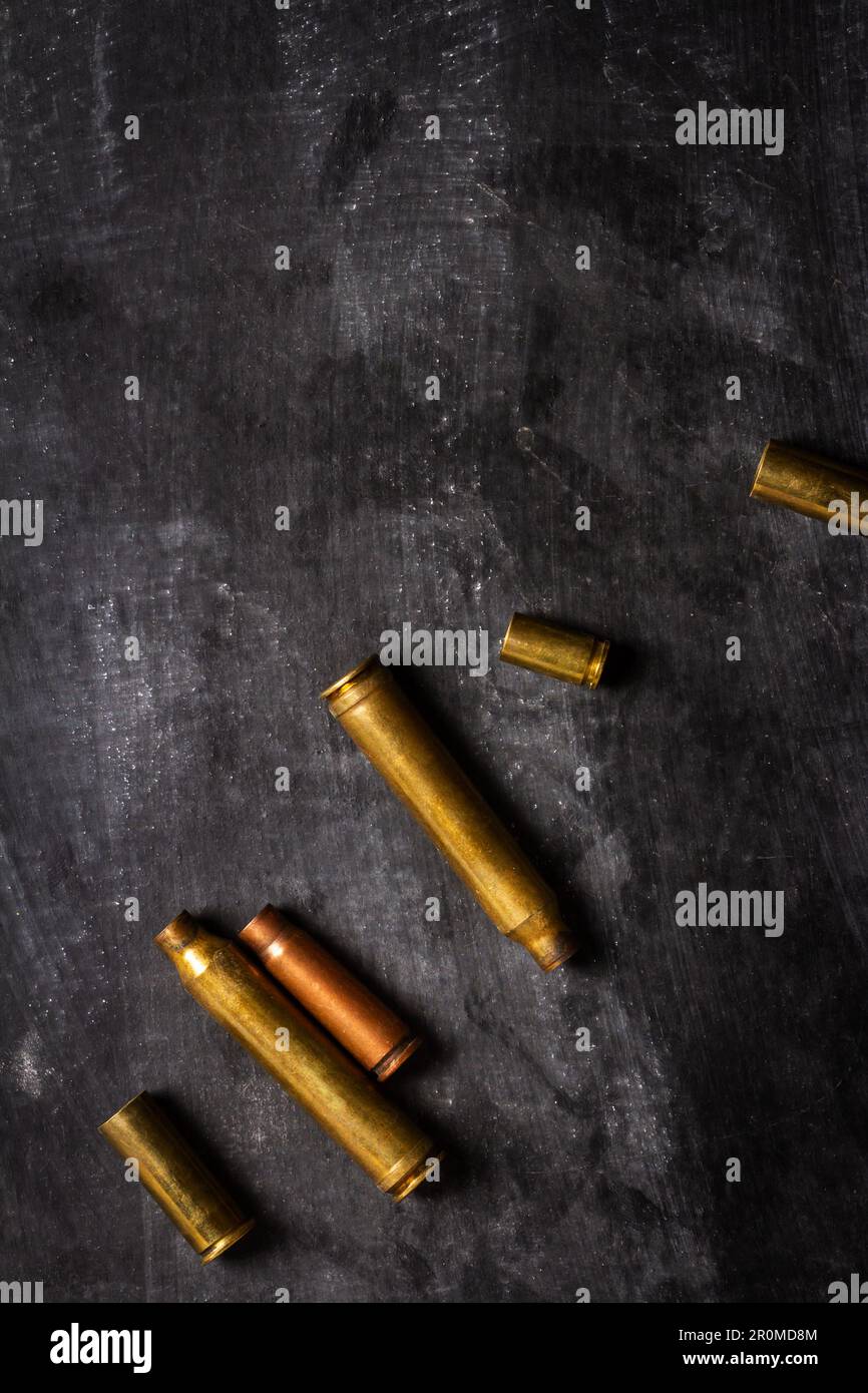 Empty bullet cartridges lying on the black background Stock Photo - Alamy