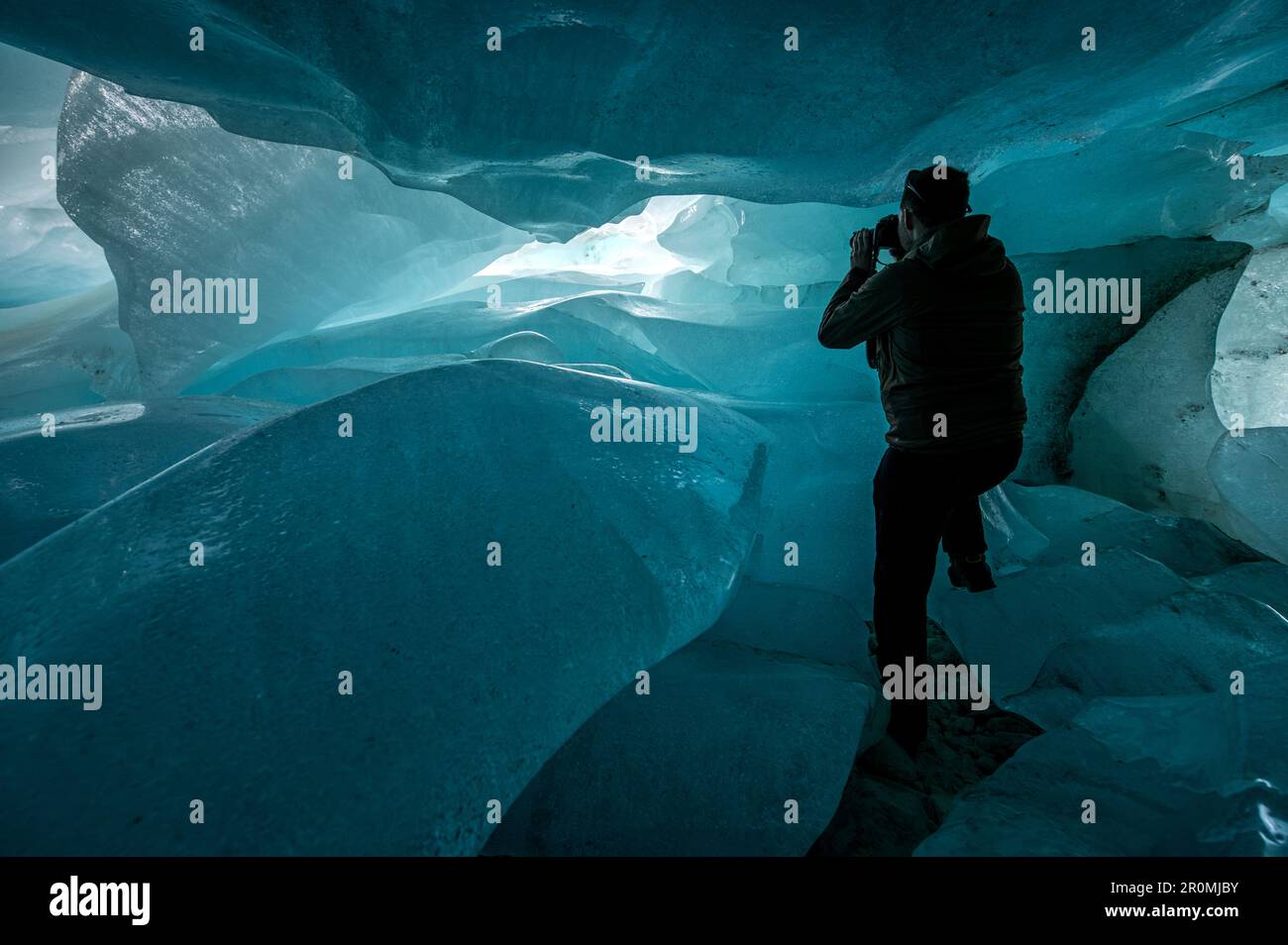 Adventure Photographer in blue ice cave in the Swiss Alps Stock Photo ...