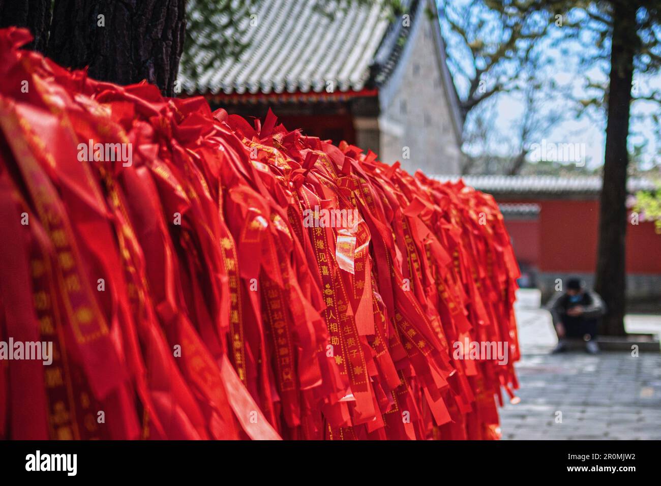 A cluster of red ribbons is displayed on the wall of an Asian temple ...