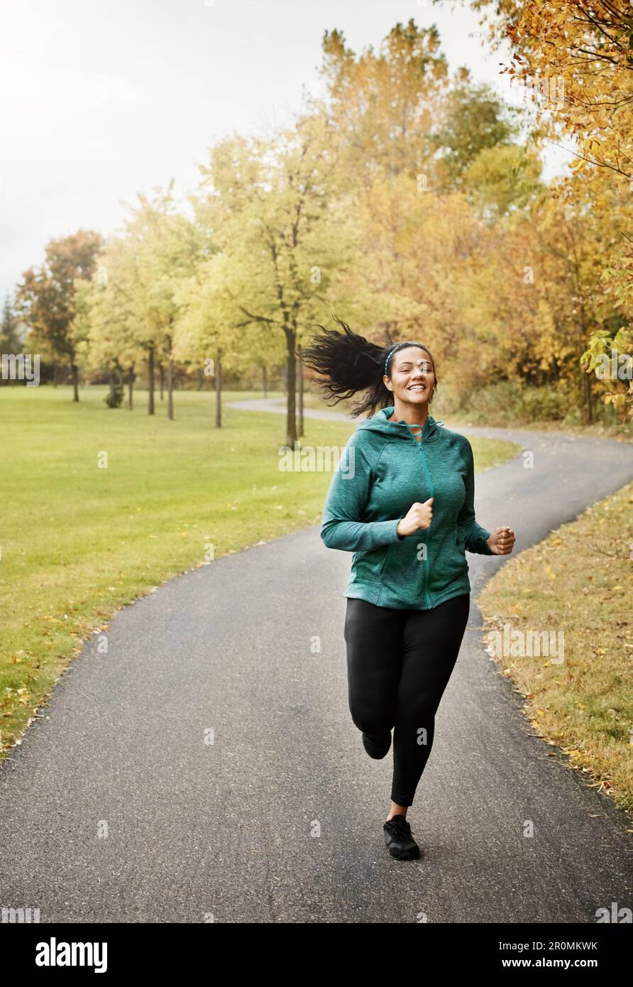 Powering through her run. Portrait of an attractive young woman going ...