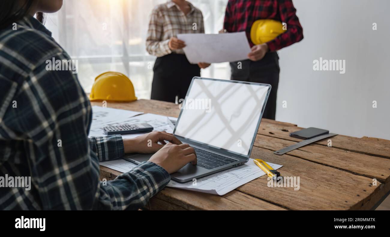Team of structural engineers working in office looking at laptop ...