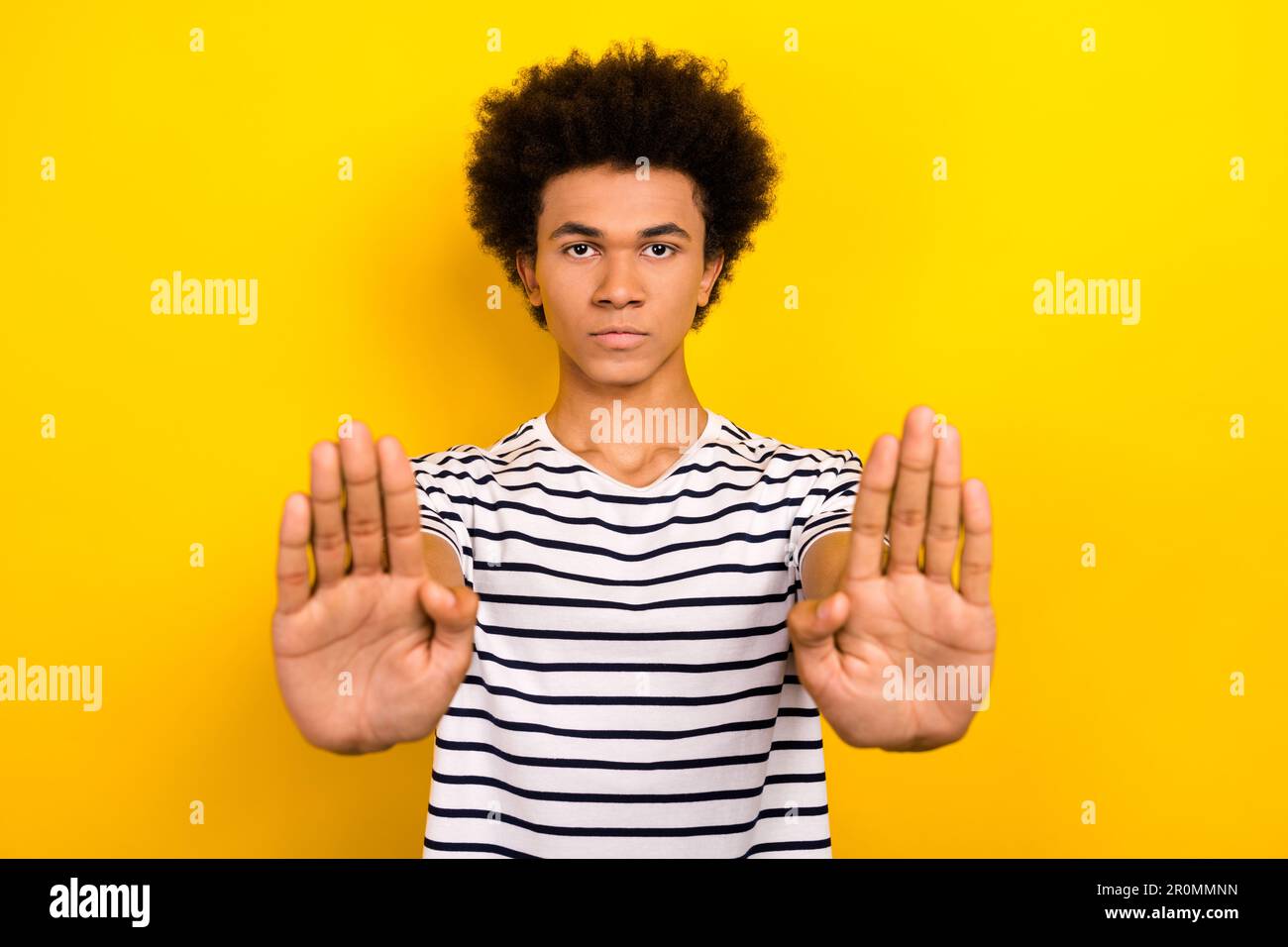 Photo serious student guy raise palms arms say no stopp unfair strike ...