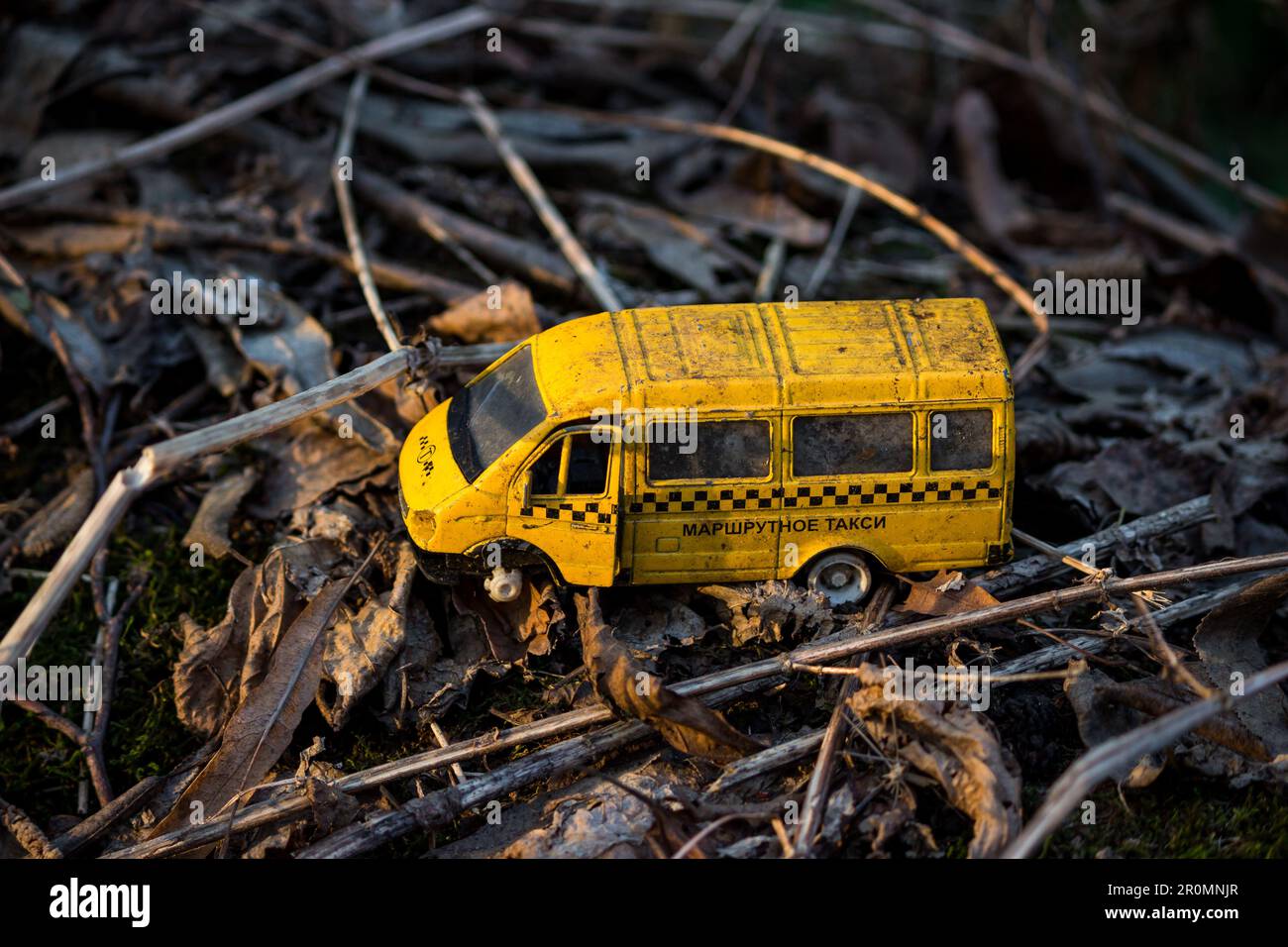 Old discarded and broken toy car in the form of a yellow taxi, small ...
