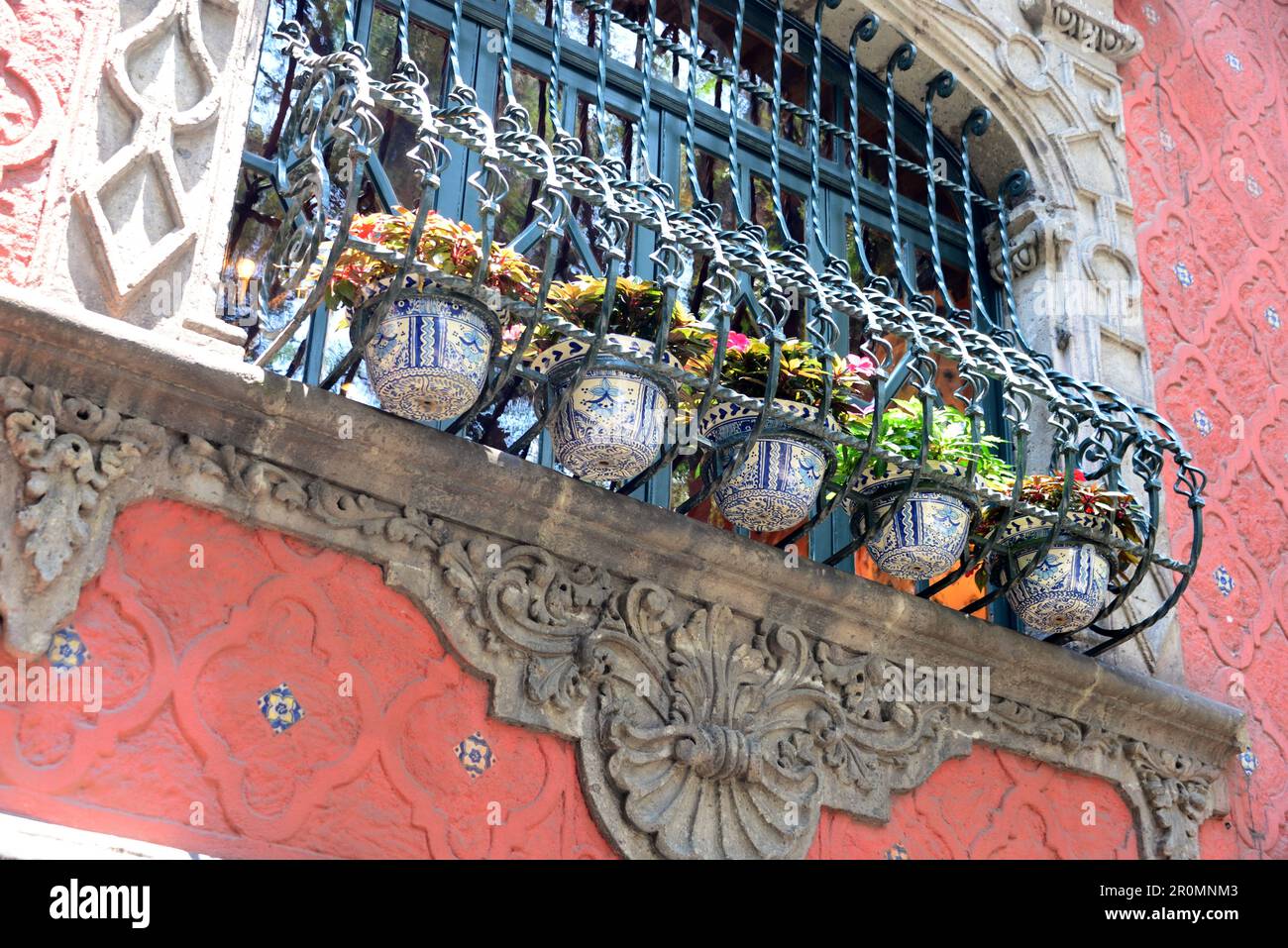 Colonial, barred window with floral decoration and red tiles on the ...
