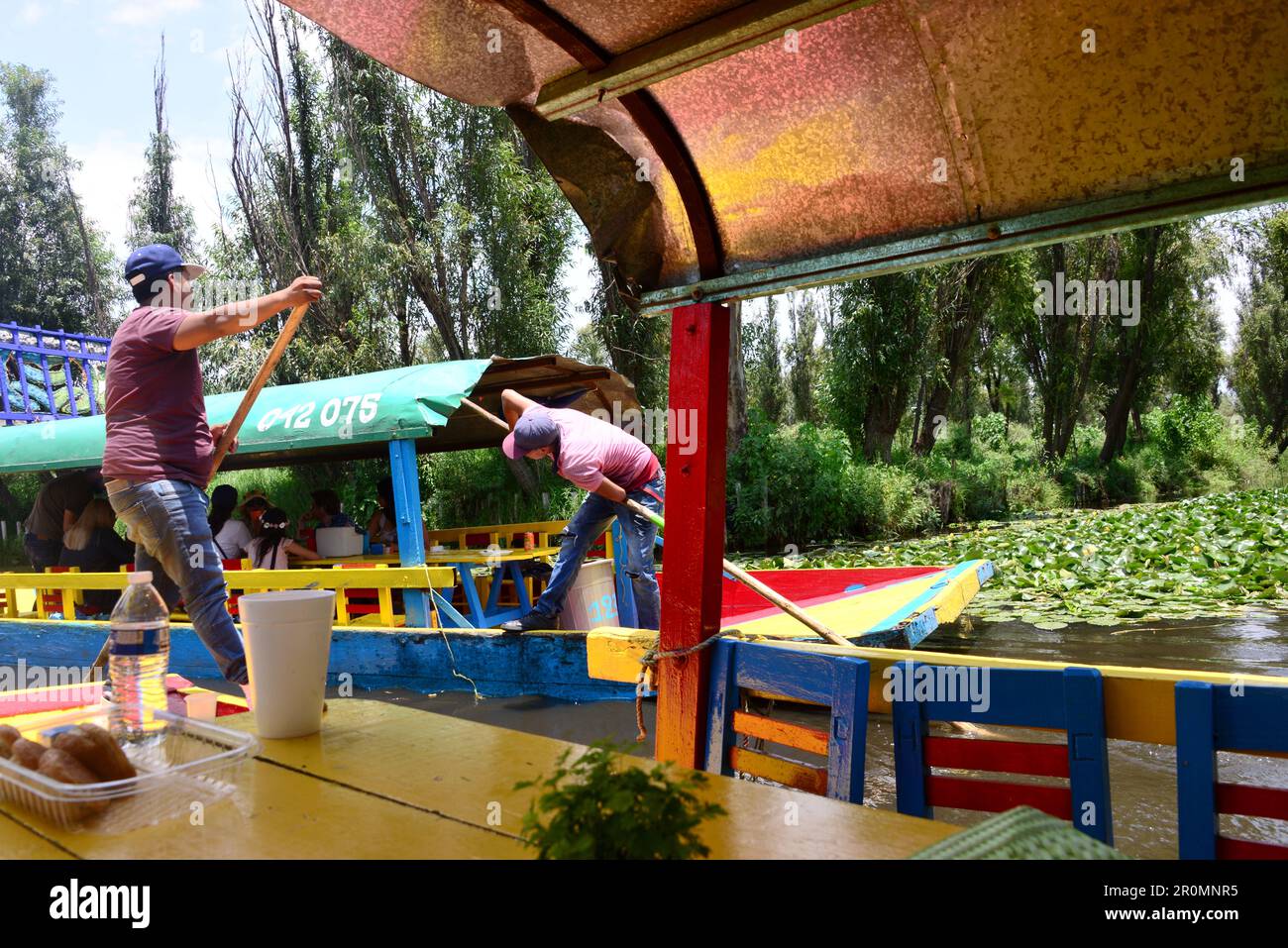 Mexican skippers on colorful boats on the canals of Xochimilco, Mexico ...