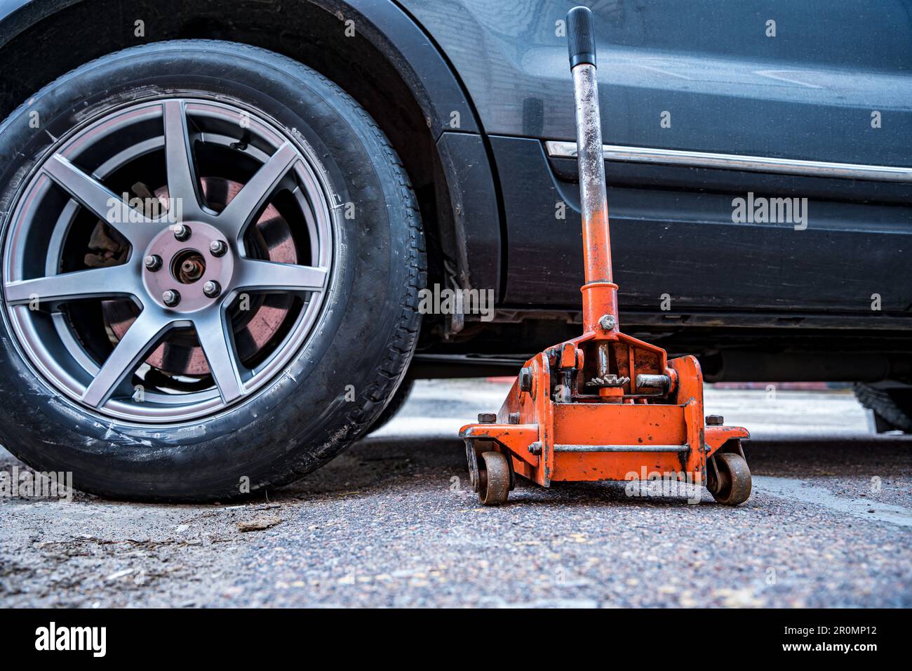 car is jacked using an automobile hydraulic jack Stock Photo - Alamy