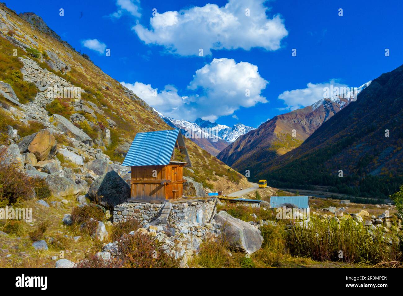A small cabin room in a mountain valley against blue sky and flying ...