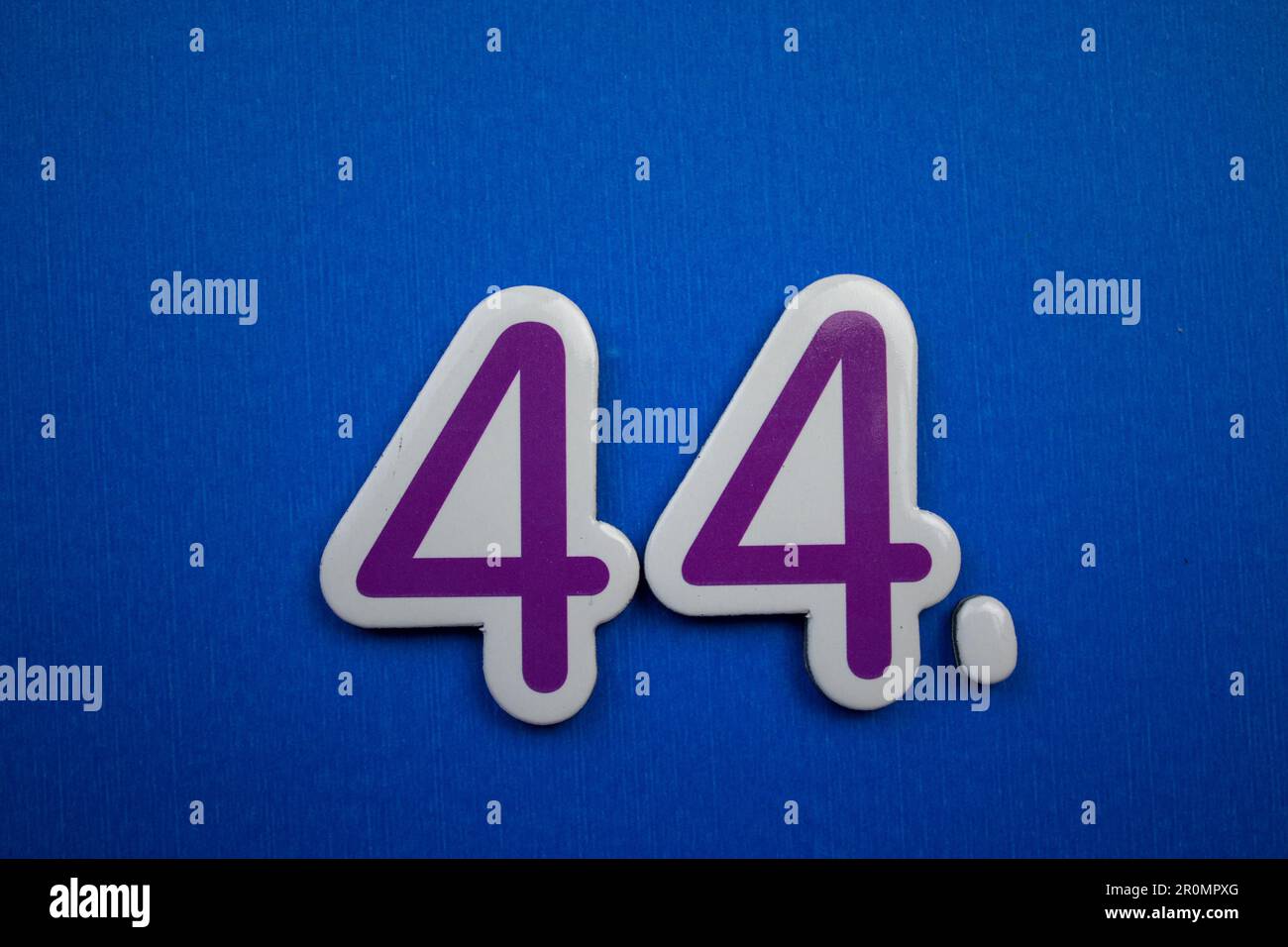 The number 44, placed on a blue background, photographed from above ...
