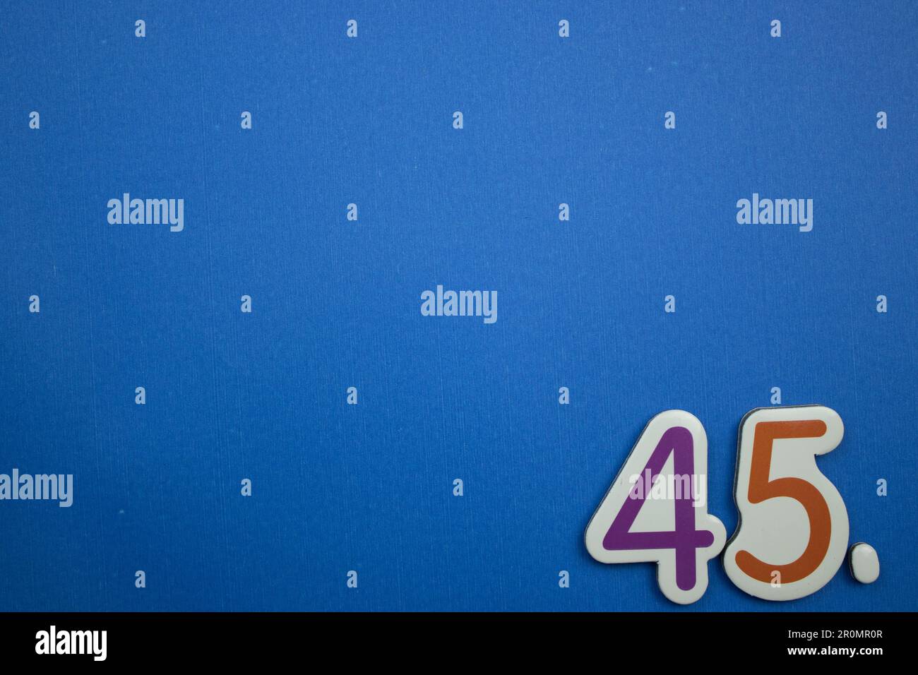 The number 45, placed on the edge of a blue background, photographed ...