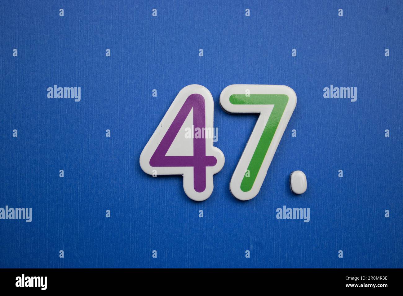 The number 47, placed on a blue background, photographed from above ...