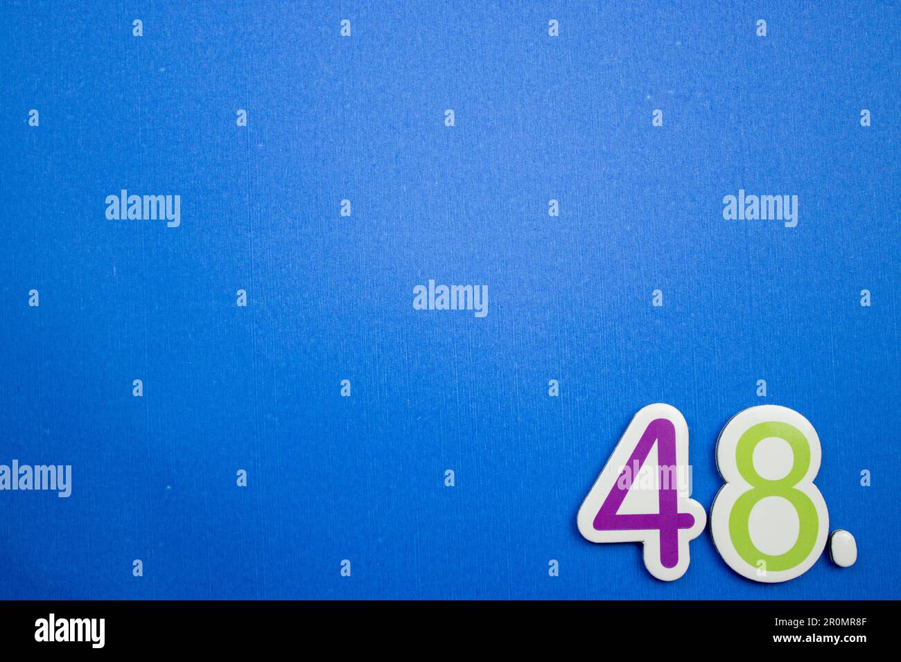 The number 48, placed on the edge of a blue background, photographed ...