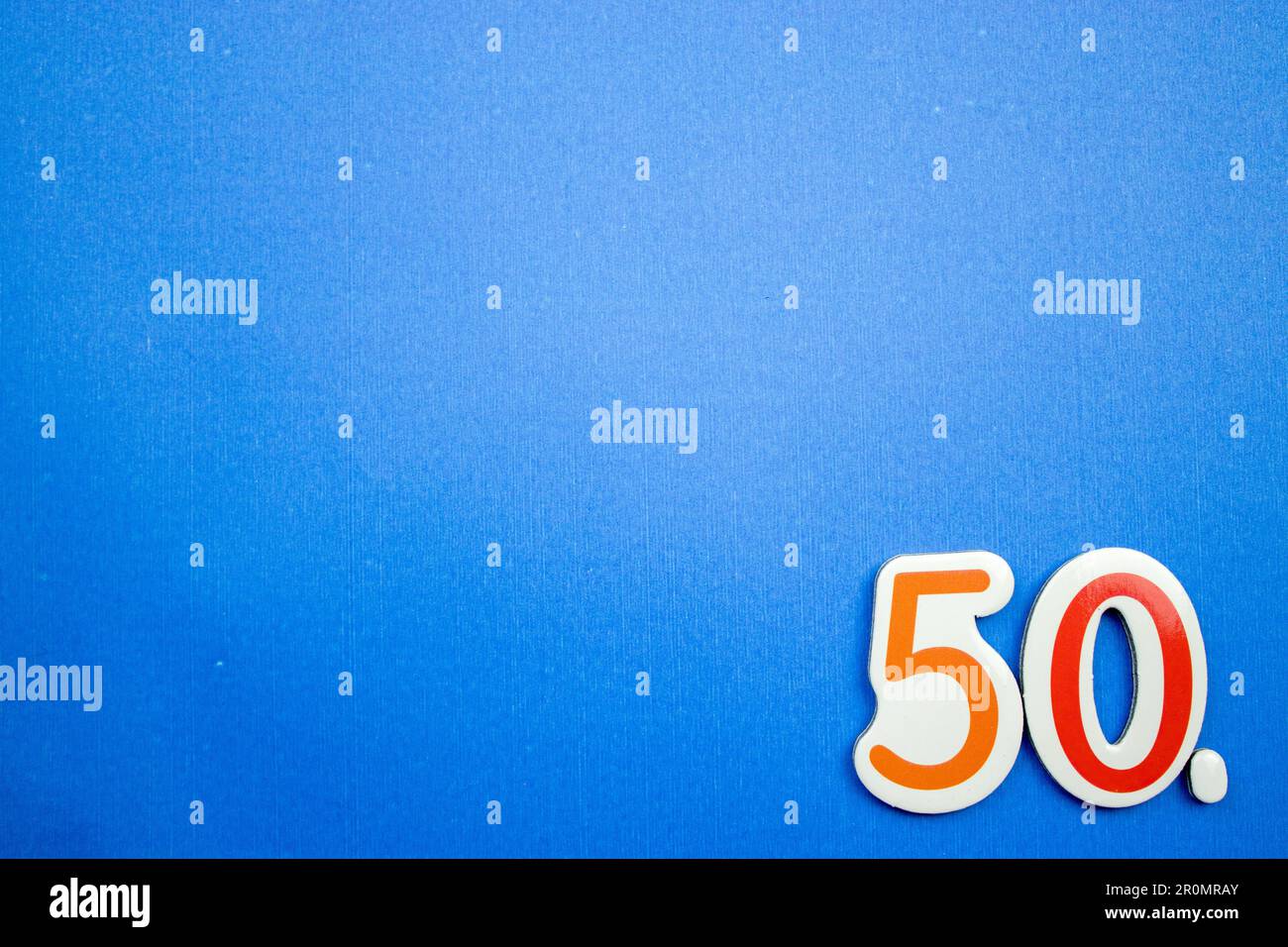The number 50, placed on the edge of the blue background, photographed ...