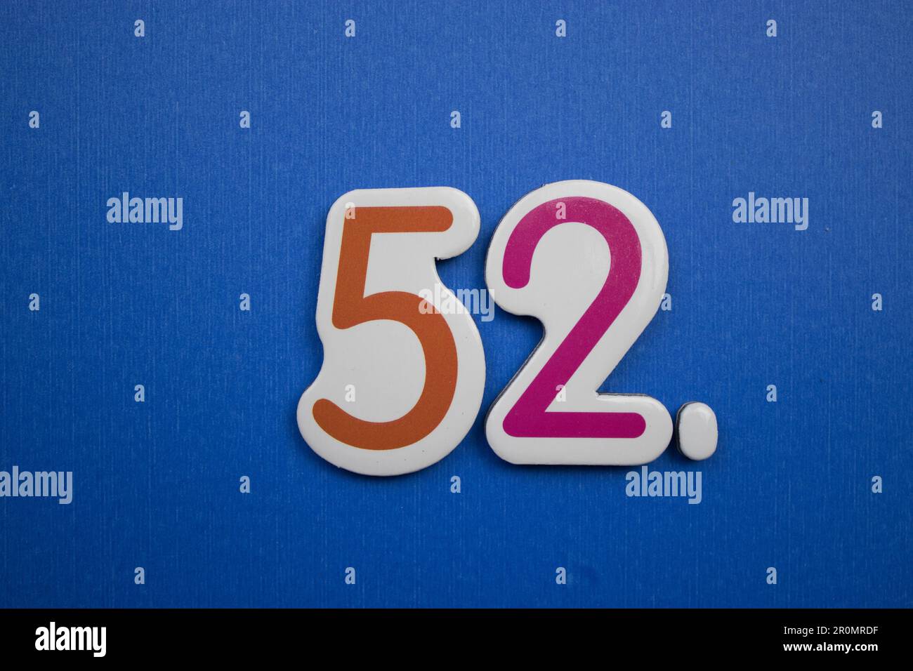The number 52, placed on a blue background, photographed from above, colored orange and red ...