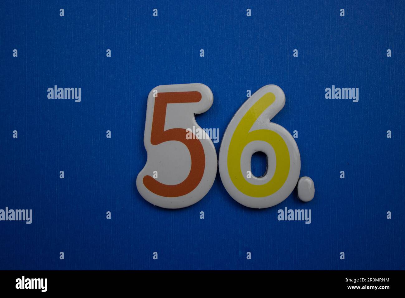 The number 56, placed on a blue background, photographed from above, colored red and yellow ...