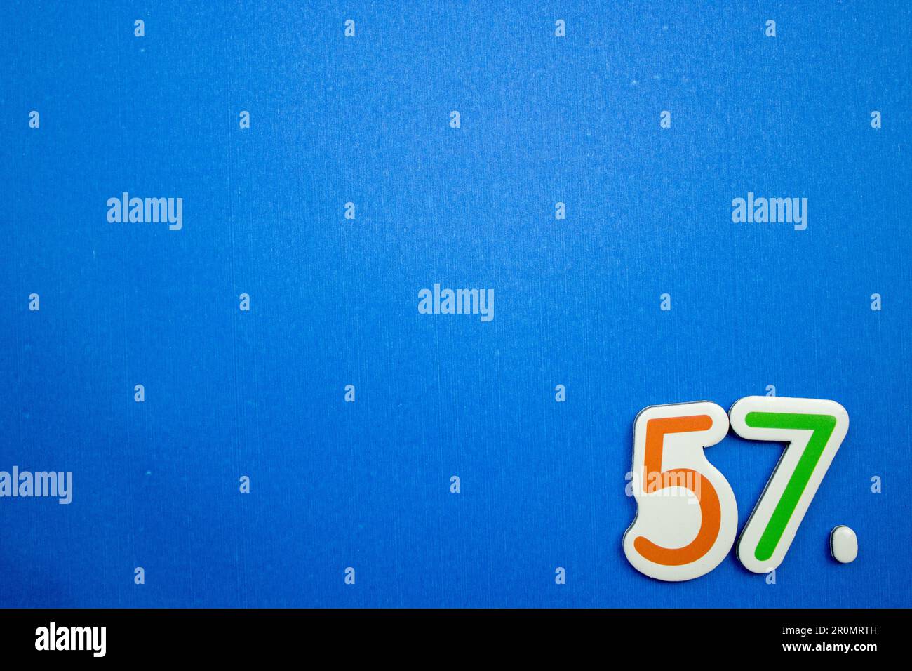 The number 57, placed on the edge of a blue background, photographed ...