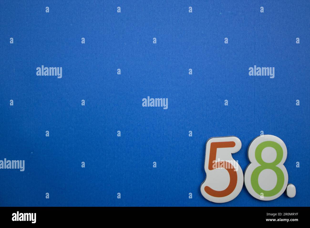 The number 58, placed on the edge of a blue background, photographed ...