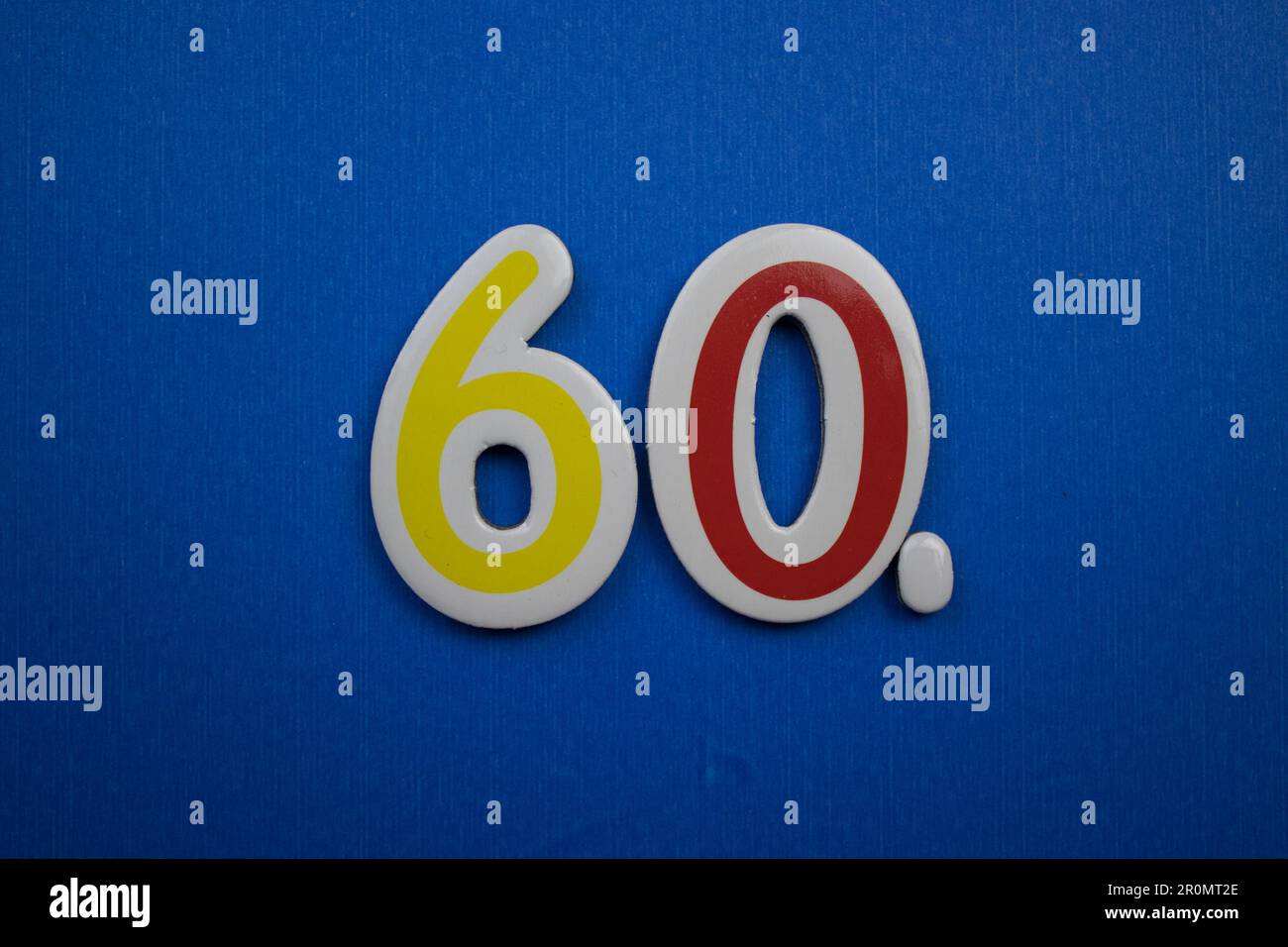 The number 60, placed on a blue background, photographed from above ...