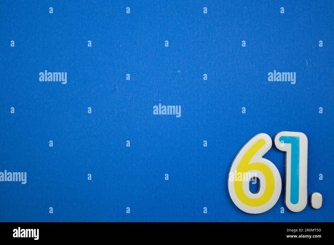 The number 61, placed on the edge of a blue background, photographed ...