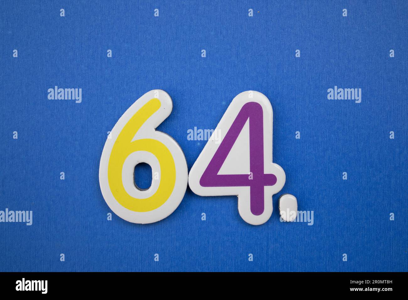 The number 64, placed on a blue background, photographed from above, colored yellow and purple ...