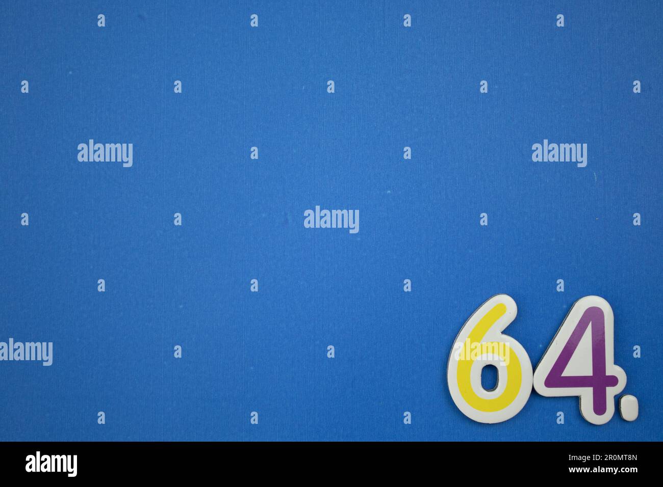 The number 64, yellow and purple, photographed from above, placed on ...