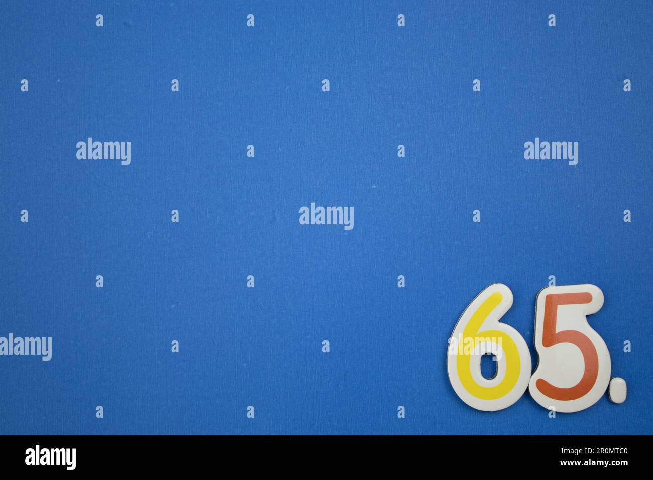 The number 65, placed on the edge of a blue background, photographed ...