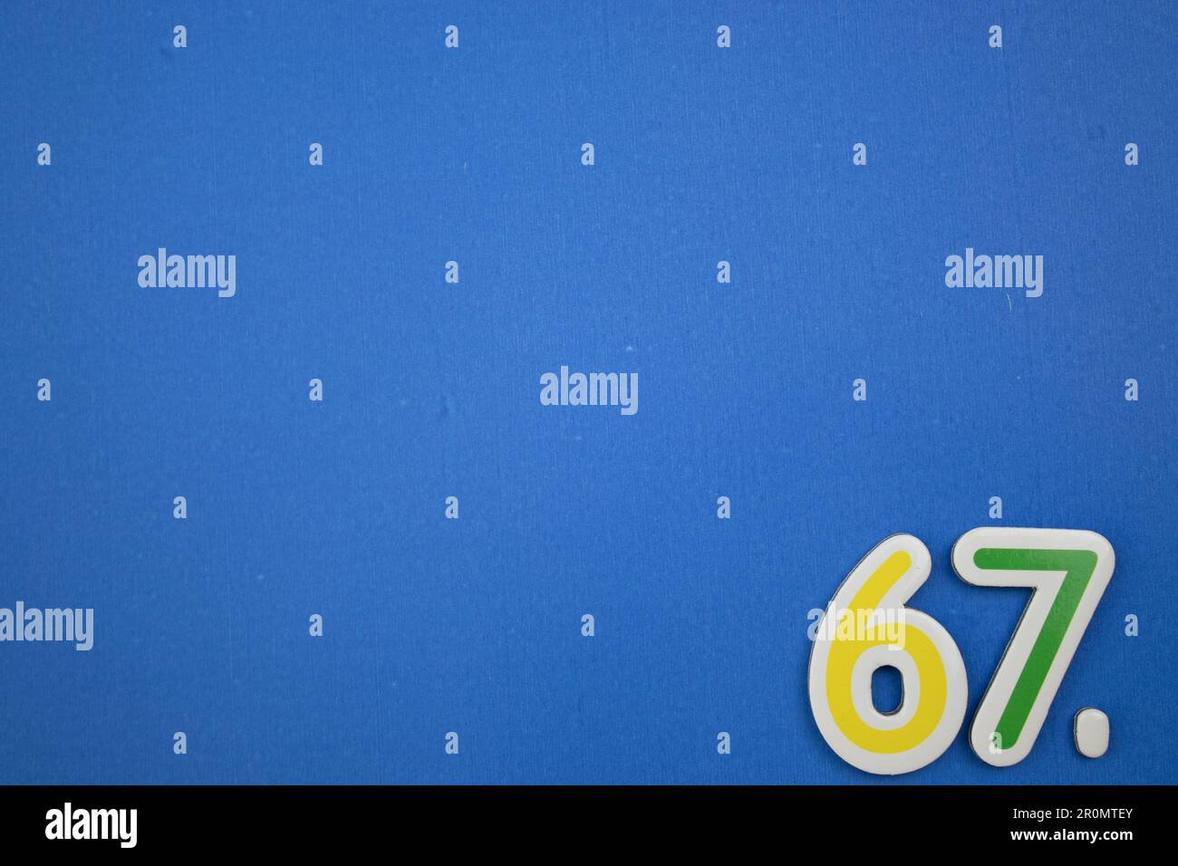 The number 67, placed on the edge of a blue background, photographed ...