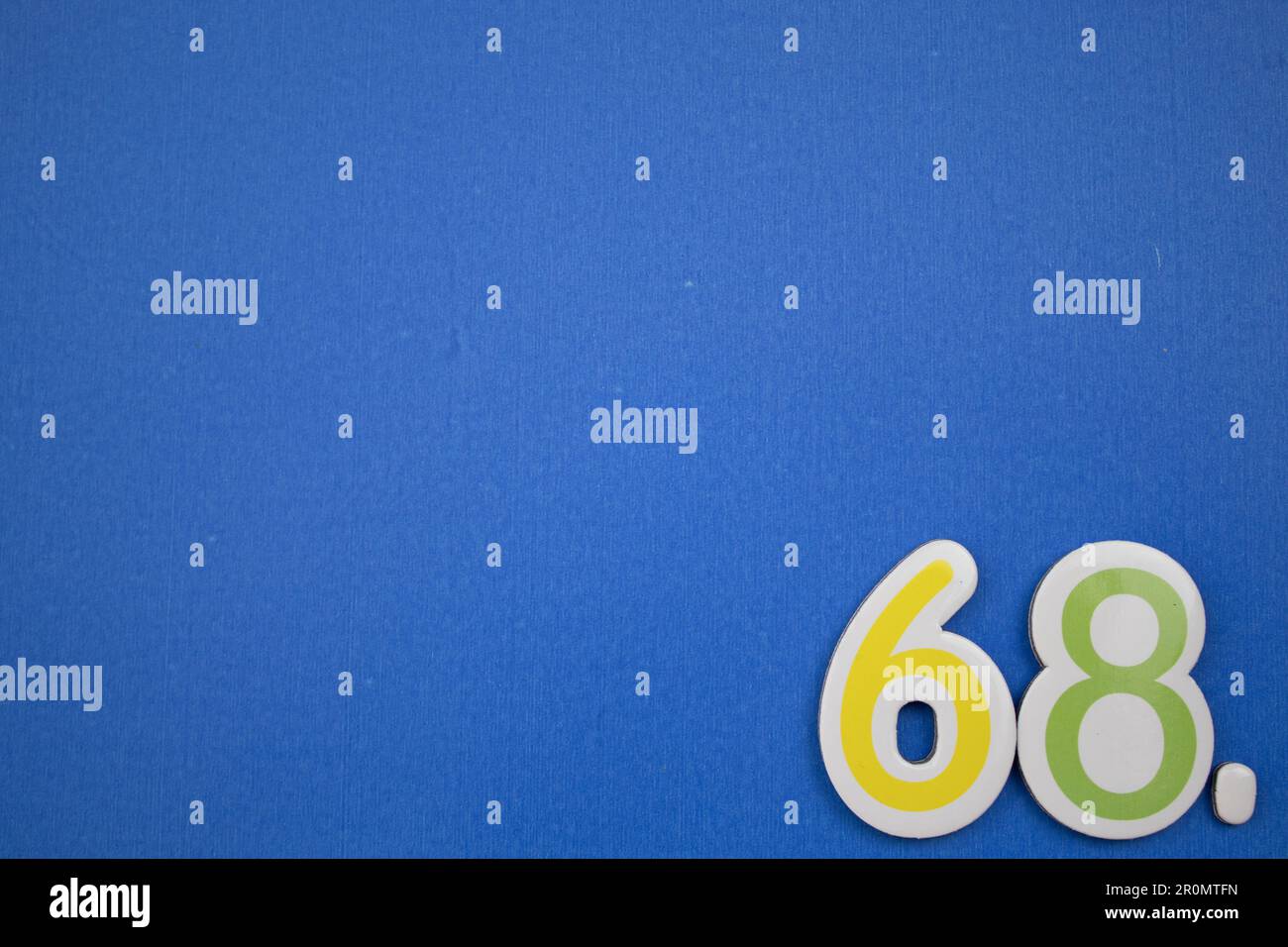 The number 68, placed on the edge of a blue background, photographed ...