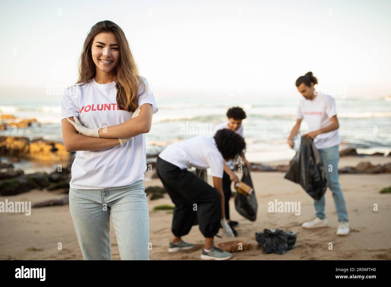 Happy young diverse people volunteers in t-shirts and asian lady with ...